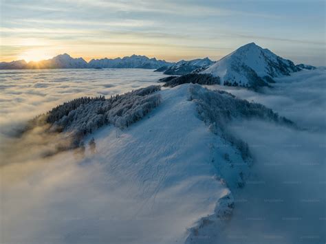 눈으로 덮여 구름으로 둘러싸인 산 사진 Unsplash의 자연 이미지