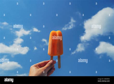 Orange Ice Creams On Blue Sky Background Orange Popsicle In Woman Hand Female Hand Holding