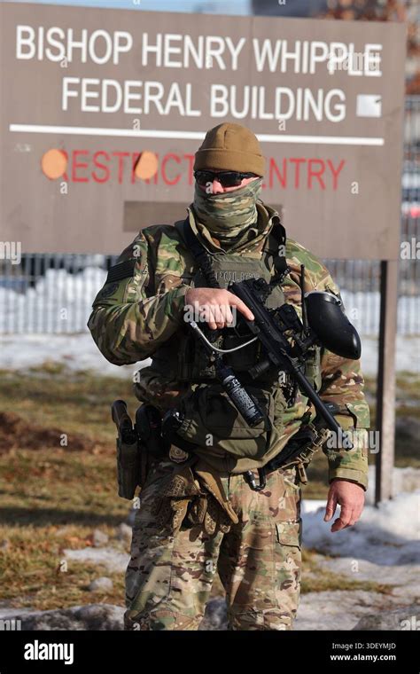 A Federal Officer Stands Outside The Bishop Henry Whipple Federal