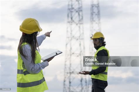 전기 엔지니어는 그 뒤에 맑은 푸른 하늘과 태양 광선 고전압 라인 근처 분야에서 작업 2명에 대한 스톡 사진 및 기타 이미지