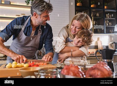 Happy Dad Preparing Ingredients For Dish While Loving Mother Standing
