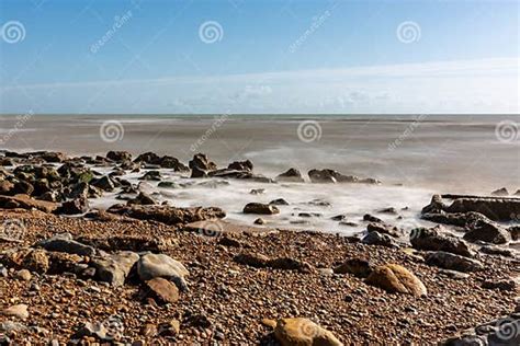 A Long Exposure Photograph Of The Shoreline At Pett Level Beach On The
