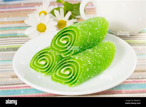 Green Fruit Candy On A Plate With Flower Chamomile Background Stock