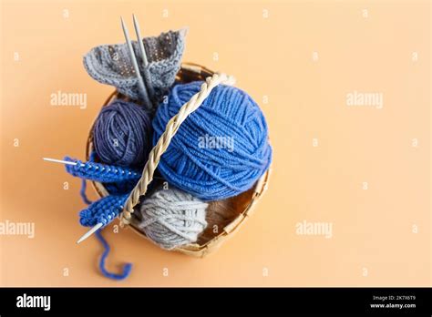 Blue Balls Of Knitting Threads On A Orange Background In A Basket With Knitting Needles Stock