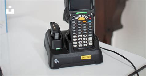 Barcode Scanner Device In Charging Dock On Table Photo Free