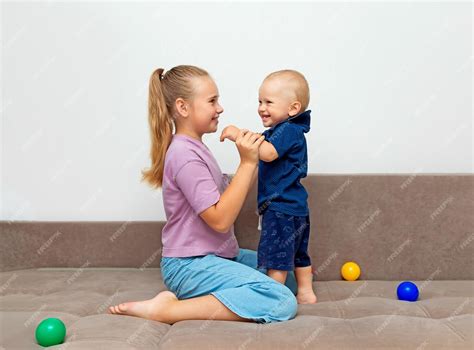 A Irmã Mais Velha Segura As Mãos De Seu Irmão Mais Novo Foto Premium