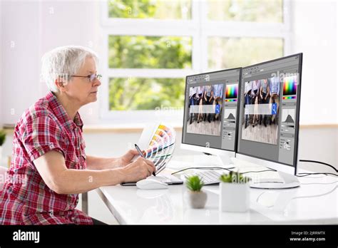 Website Graphic Designer Working In Office On Multiple Screens Stock