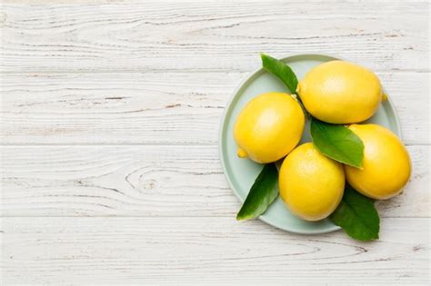 Premium Photo Fresh Cutted Lemon And Whole Lemons Over Round Plate On