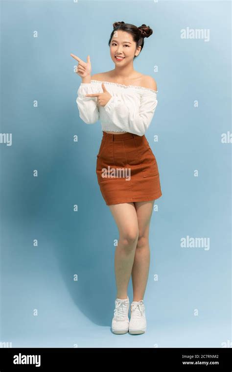 Beautiful Girl Standing Over Isolated Blue Background Smiling Pointing With Two Hands And