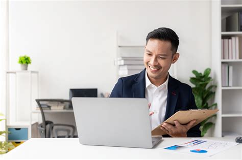 금융 그래프 차트 마케팅 정보 계획을 작성하는 아시아 사업가 책상에서 노트북을 사용하여 계산 및 분석을 위해 재무 문서 스프레드