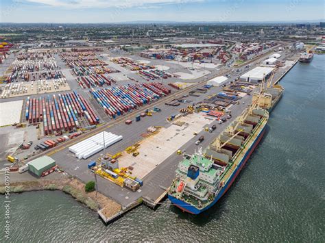 Aerial View Of A Cargo Ship With Its Holds Open At Wharf Lined With