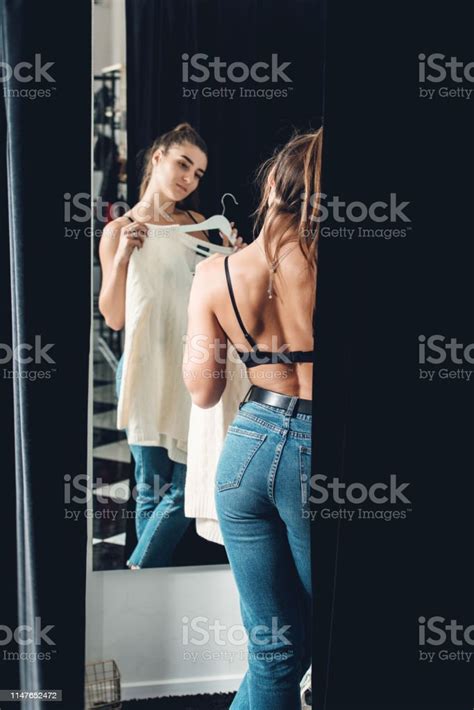 Young Beautiful Woman Shopping In A Fitting Room In Fashion Mall Trying