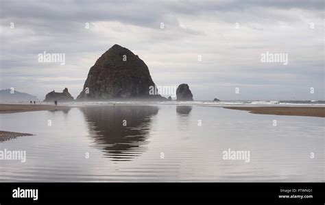 Haystack Rock Reflected In The Tide Pools Of Cannon Beach Oregon At