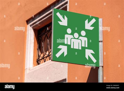 Emergency Assembly Point Closeup Of A Green Sign In A City Against A