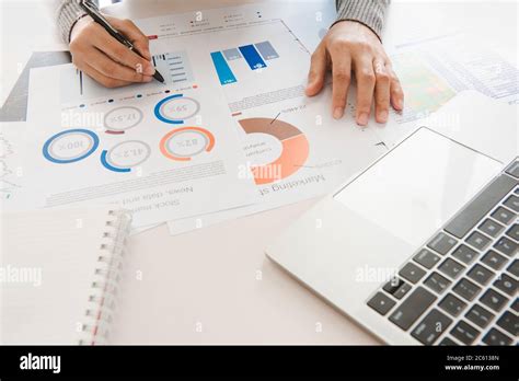 Businesswoman Analyze Document In His Handsgraphs And Diagramm On