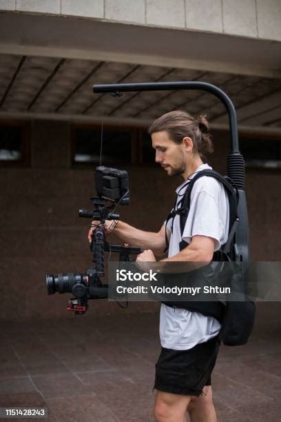 Videografer Profesional Memegang Kamera Pada Gimbal 3sumbu Yang Dipasang Pada Rig Mudah