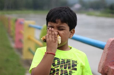Premium Photo Boy Eating Roasted Corn Outdoors