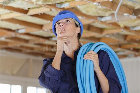 Constructor De Sexo Femenino Que Sostiene Los Cables Mientras Que Trabaja En Techo Imagen De