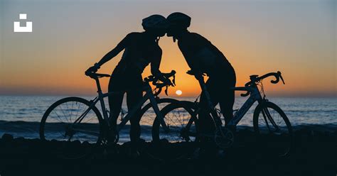 자전거 근처에 서 있는 해변에 서 있는 두 사람의 실루엣 사진 사진 Unsplash의 무료 카레테라 라 플라야 이미지