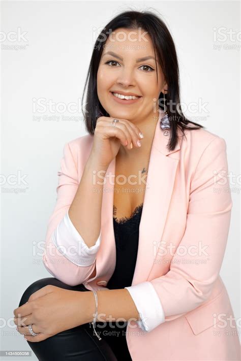 Portrait Of Beautiful Adult Brunette Woman With Smile Sitting In Light