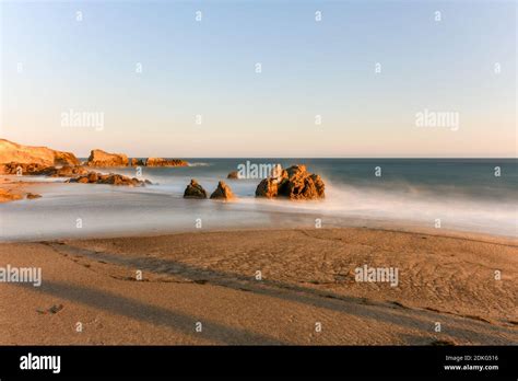 Stunning Long Exposure View Of Smooth Waves Crashing Into Rock