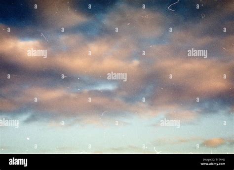 Grunge Image Of Evening Sky With Clouds On Grainy And Dusty Film
