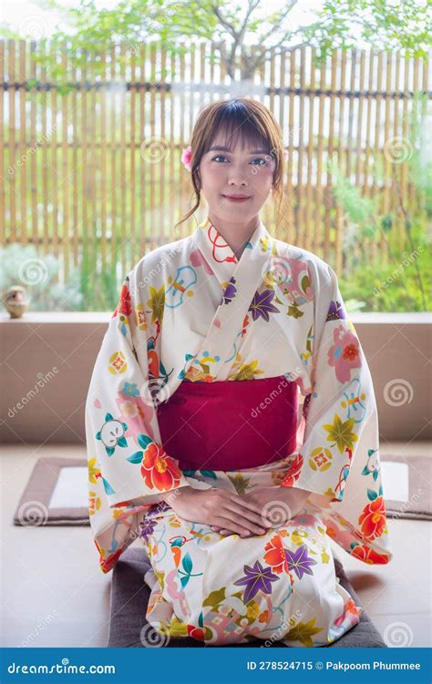 Young Woman Wearing Traditional Kimono Sitting In Japanese Style House