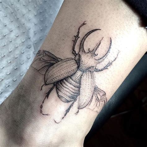 A Tattoo On The Leg Of A Person With A Beetle Crawling On Its Arm