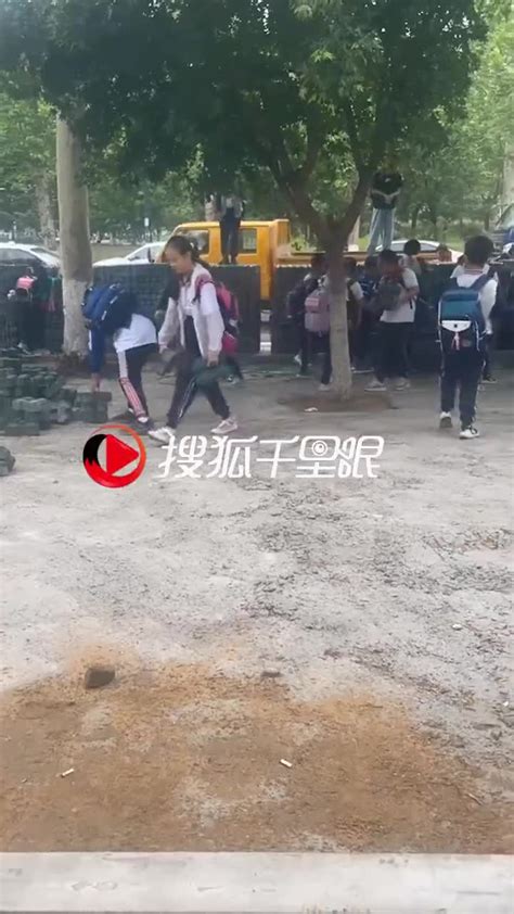 小学生等校车间隙帮工人大叔搬砖 拍摄者：20人花了五六分钟，大大减轻了工人工作量手机新浪网