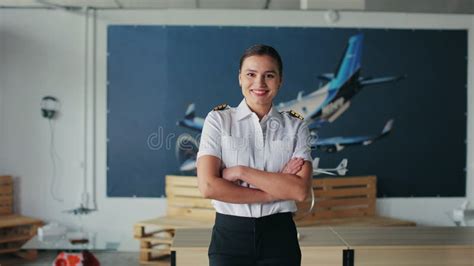 Female Instructor Pilot Standing In Classroom Looking At Camera