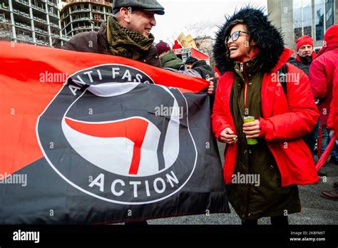 A Man Holding An Antifa Flag Is Talking With A Woman During The