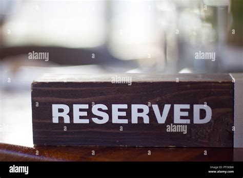 Reserved Wooden Card Plate On The Table With Blurry Background