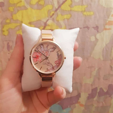 ساعة ذهبية بنقشة فلورال من ناين ويست بتصميم كلاسيكي