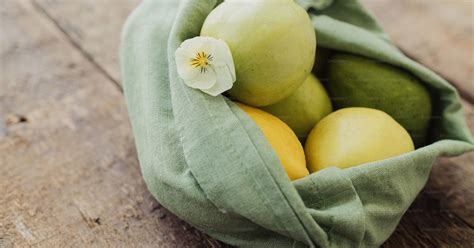 제로 폐기물 쇼핑 개념 신선한 사과 아보카도 소박한 나무 테이블에 꽃이 있는 에코 면 가방에 레몬 녹색 재사용 가능한 가방에 유기농 과일과 채소 친환경 플라스틱