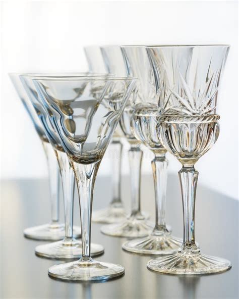 Wine And Martini Glasses Set Up In Verticle Rows On A Reflective Table