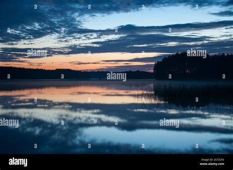 Blue And Orange Evening Colors By A Calm Lake In The Forests Of