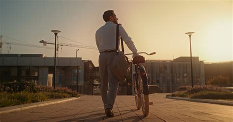 자전거 일몰 및 지속 가능한 교통 수단을 갖춘 도시 거리 또는 야외에서 사업가 여행 자전거 타기 남성 직원은 도시 도로에서 친환경 자전거를 걷고 밀면서 생각합니다 사색에