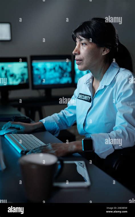 Young Serious Woman In Security Uniform Concentrating On Watching Cctv On Computer Screen While