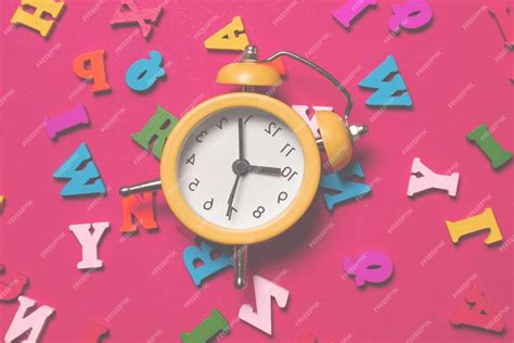 Premium Photo Random Colorful Alphabet And Yellow Alarm Clock On A