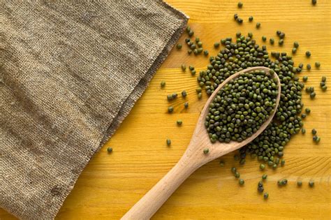 Sendok Kayu Dengan Kacang Mung Hijau Kering Dan Goni Di Atas Meja Kayu