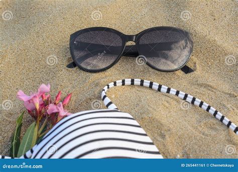 Beautiful Sunglasses Swimsuit And Tropical Flower On Sand Closeup