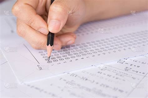 学生手持铅笔在答题纸和数学问题纸上写下选定的选项。学生考试做考试。学校考试素材 花瓣网