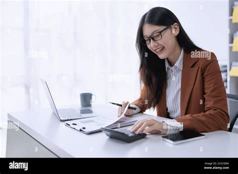 Woman Meticulously Plans A Finance Audit Using A Computer And Calculator To Review Budget