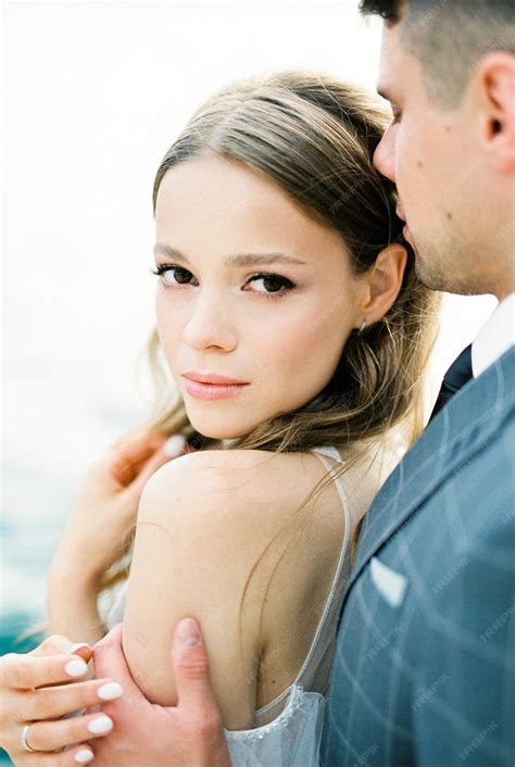 Premium Photo Man Hugs Woman From Behind Touching Her Hair With His