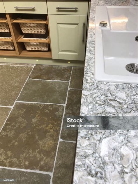 회색과 흰색 대리석 화강암 조리대 표면 위의 고급 부엌의 이미지 과일및 야채 부엌 싱크대및 서랍에 의해 오리 달걀 녹색 긴 크롬 손잡이와 돌 바닥 타일 바닥에 의해 고리버들