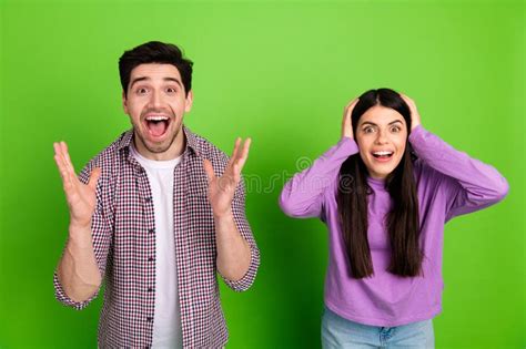 Excited Young Couple With Expressive Gestures Exclaiming Surprise Against A Vibrant Green