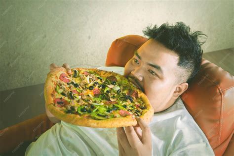 Premium Photo Fat Man Eating A Big Pizza With Gluttony Expression