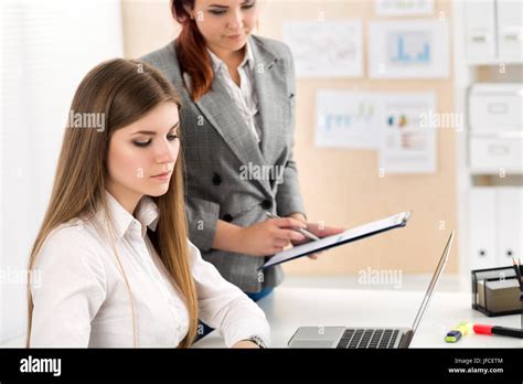 Two Female Auditors Looking At Financial Report Analyzing Tables And