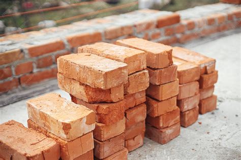 Premium Photo Stack Of Red Bricks On Concrete Foundation Process Of House Building Concrete