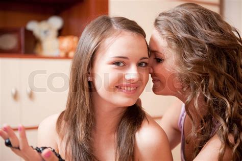 Junges Mädchen Flüstert Ein Geheimnis Zu Ihrer Freundin Stock Bild